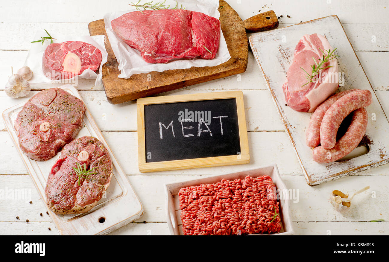 Variety of meat on a white wooden board. Food high in protein. View ...