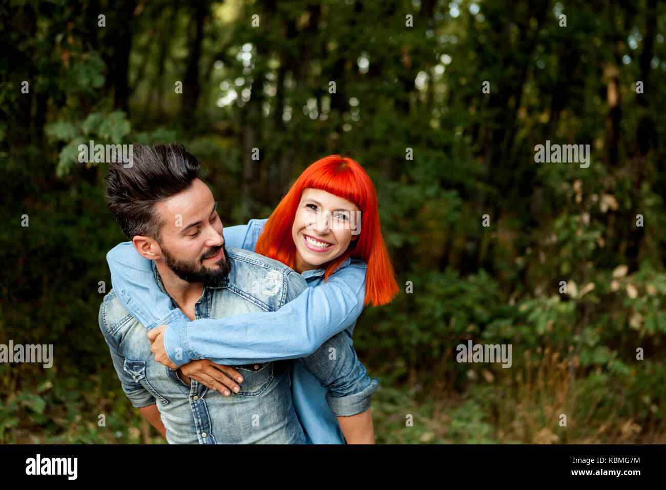 Handsome guy giving piggyback ride to girlfriend in a park Stock Photo ...