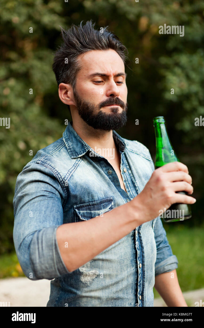 Hipster man with beard drinking a beer Stock Photo - Alamy
