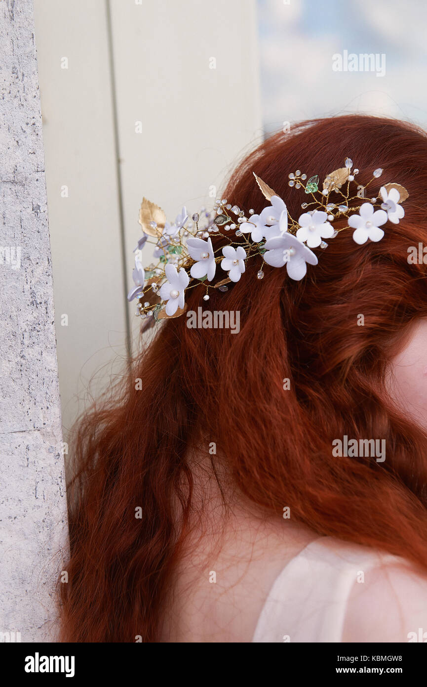 Beautiful red-haired bride sits back .Slightly visible profile. Long ...
