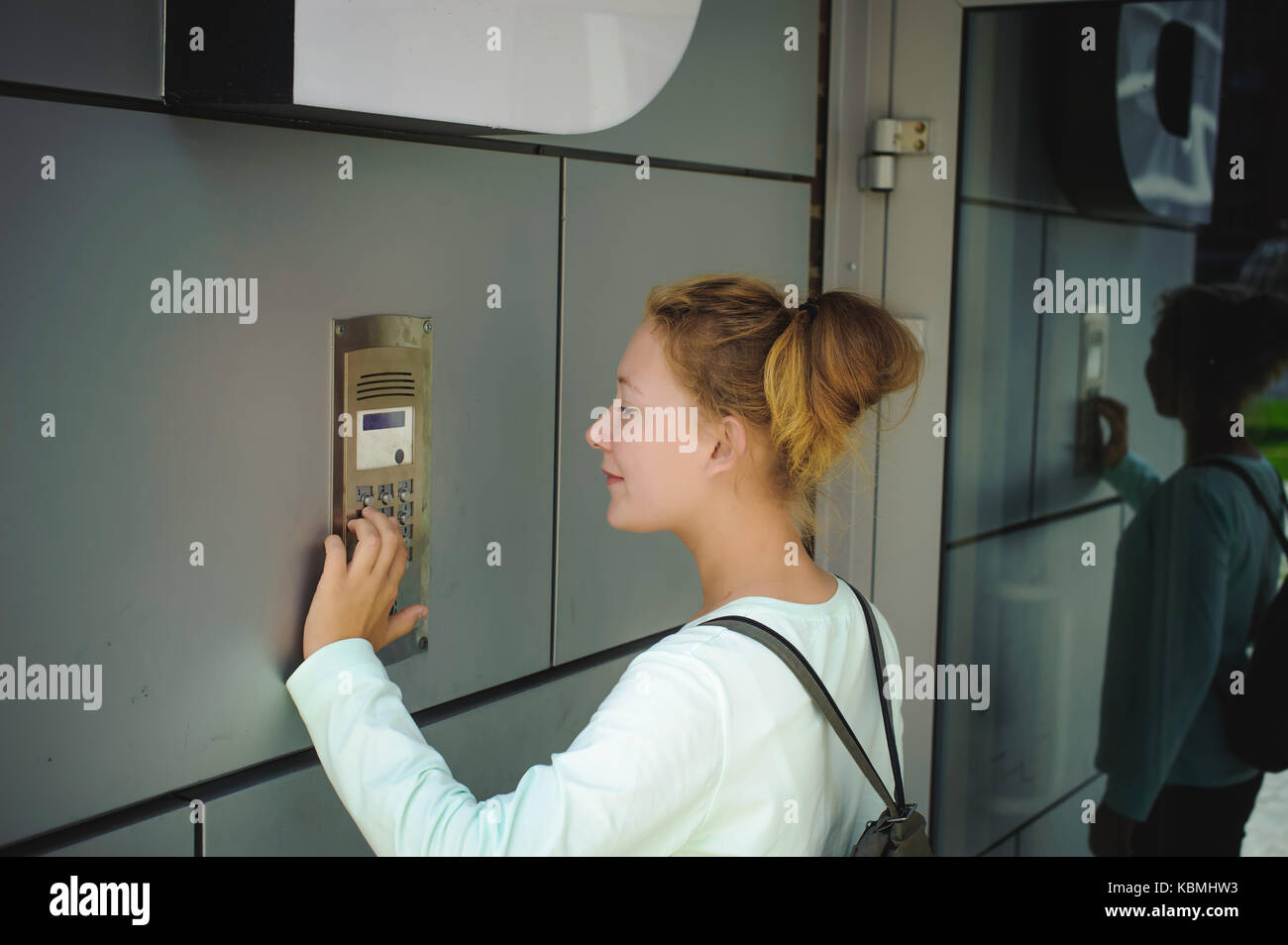 young blond teenager schoolgirl dials the code for a call over the ...