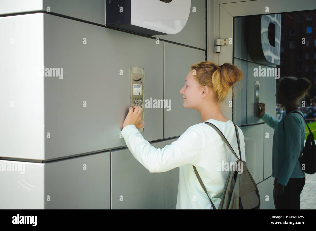 young blond teenager schoolgirl dials the code for a call over the ...