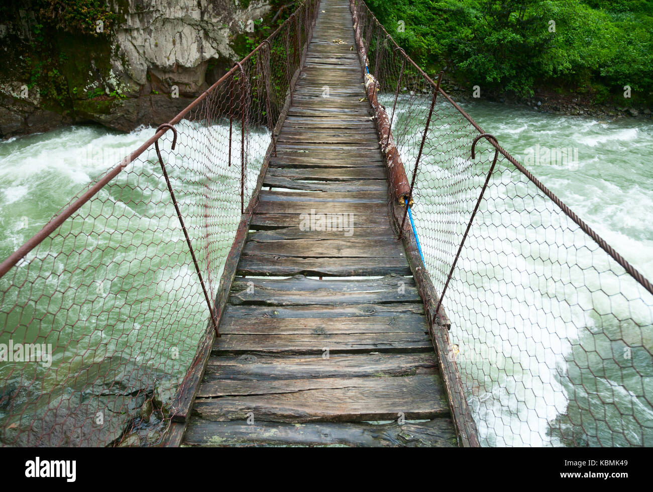 Rickety foot bridge over white water Stock Photo - Alamy