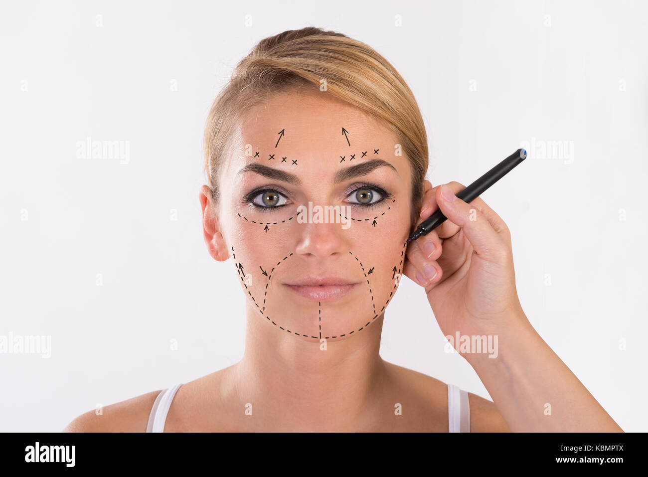 Portrait of young woman undergoing facelift surgery over white ...