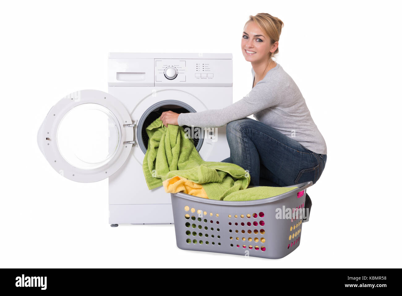 Young woman loading washing machine over white background Stock Photo ...