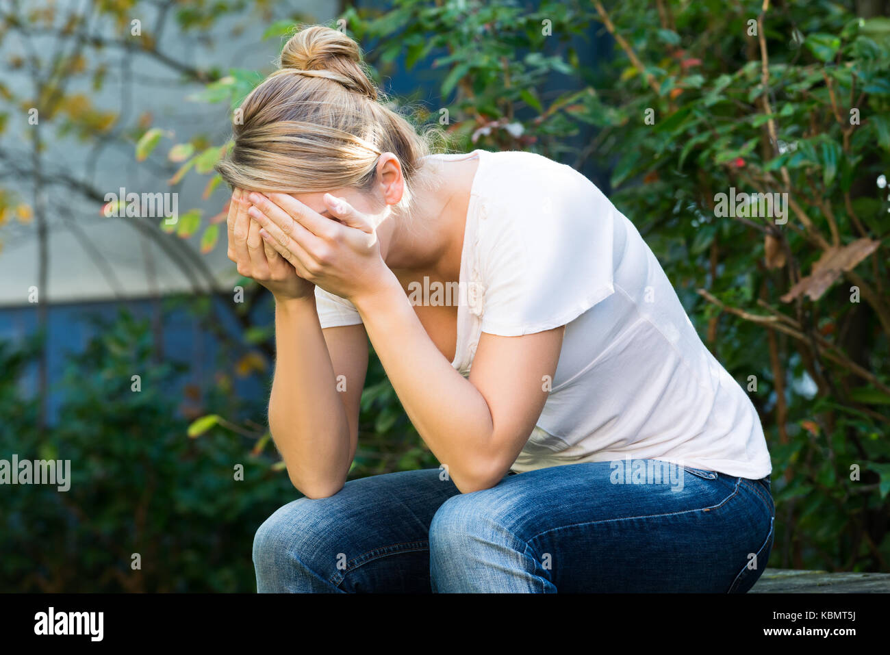 Tensed young woman covering face with hands Stock Photo - Alamy