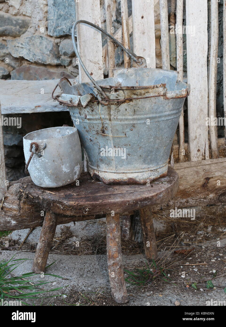 old broken tin bucket and an pot over the stool of the old abandoned ...