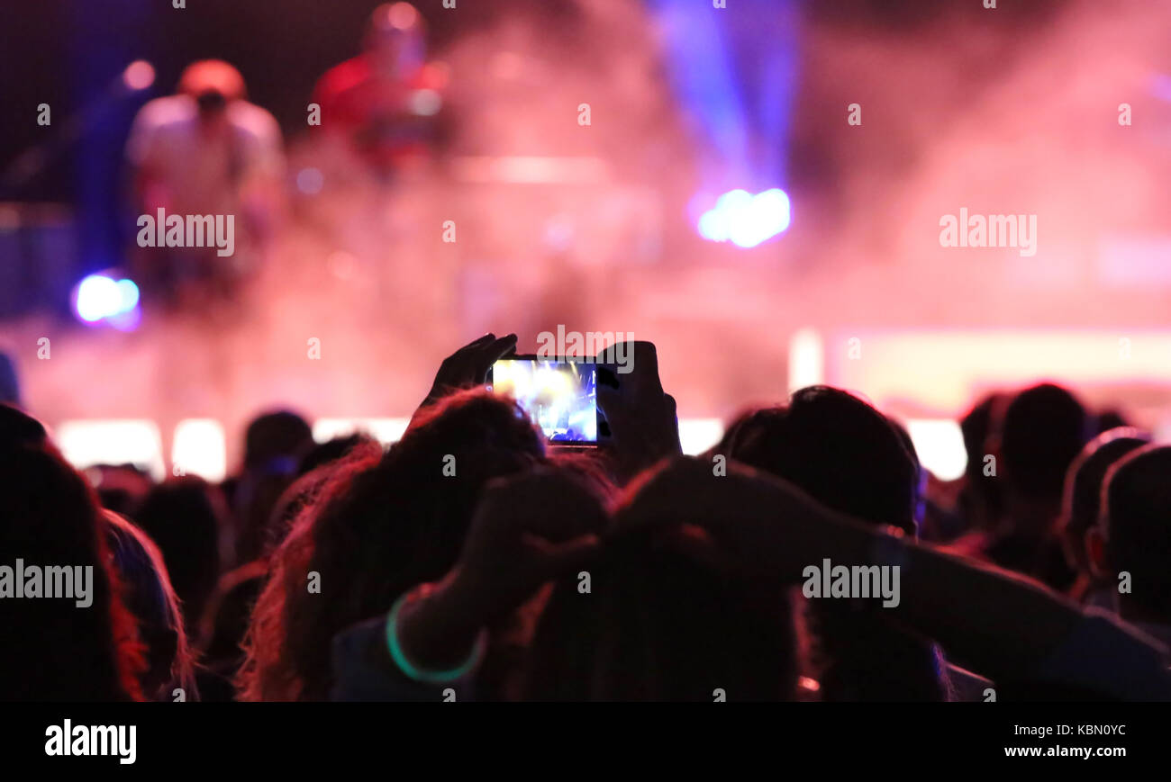 fans who take photos and record videos with modern smartphones during ...