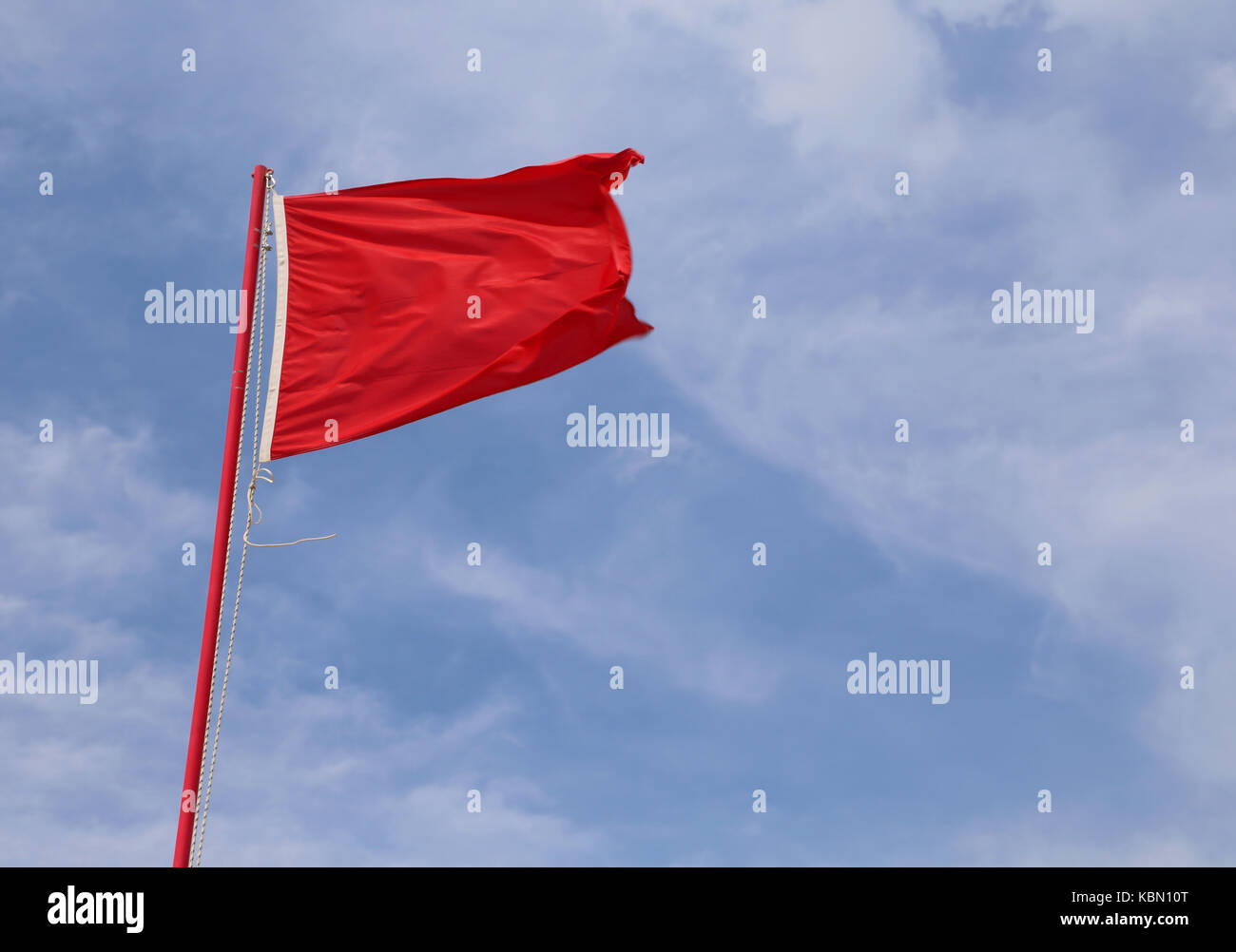 red flag indicating a state of danger and alarm with background of blue ...