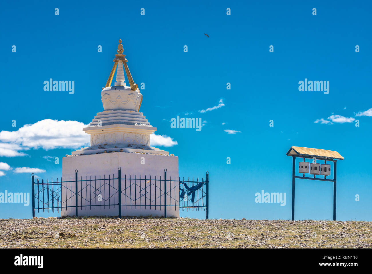 ancient traditional white stupa surrounded by metal fence at sunny day ...
