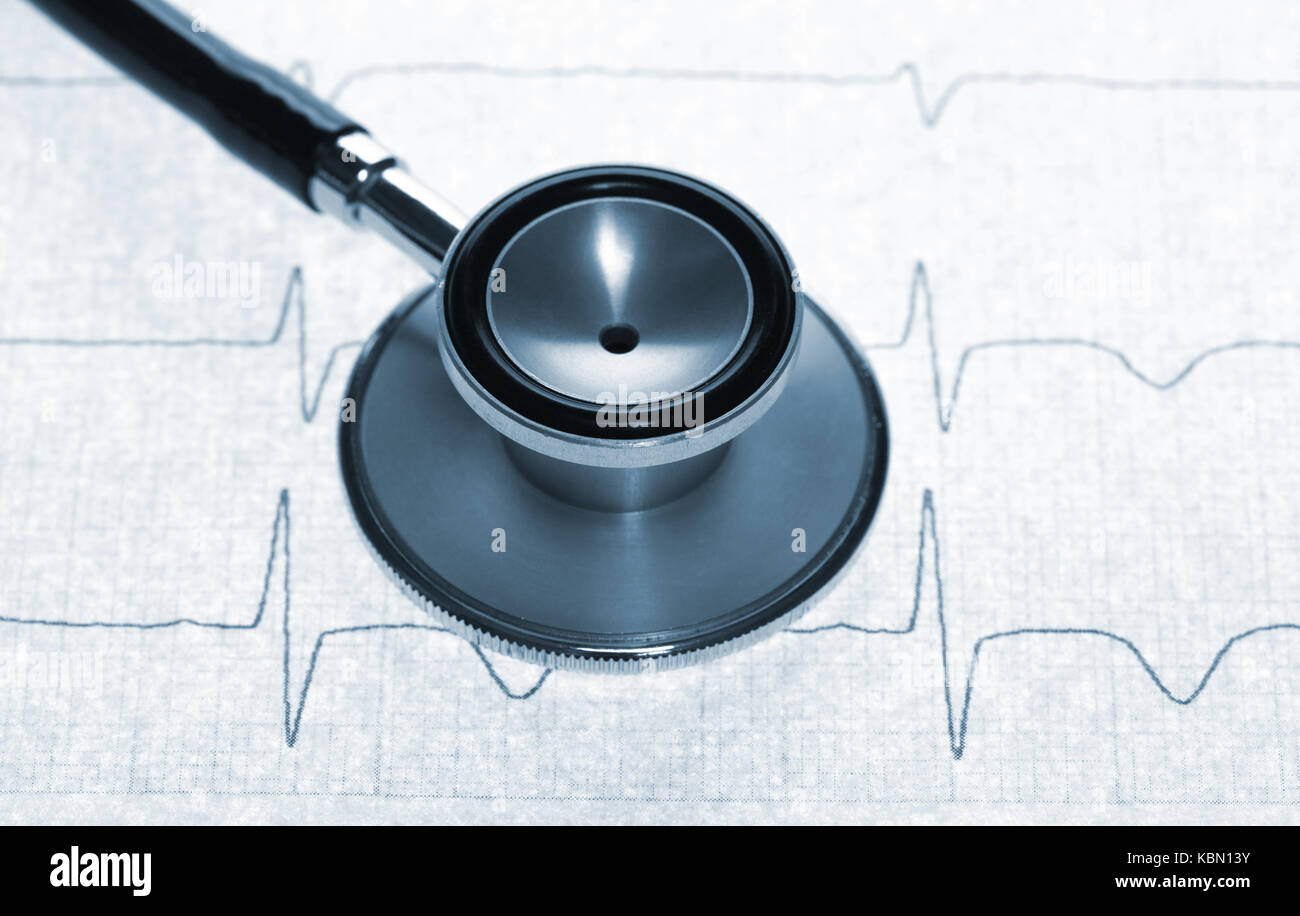 Close up view of a stethoscope on electrocardiogram background. Tinted ...