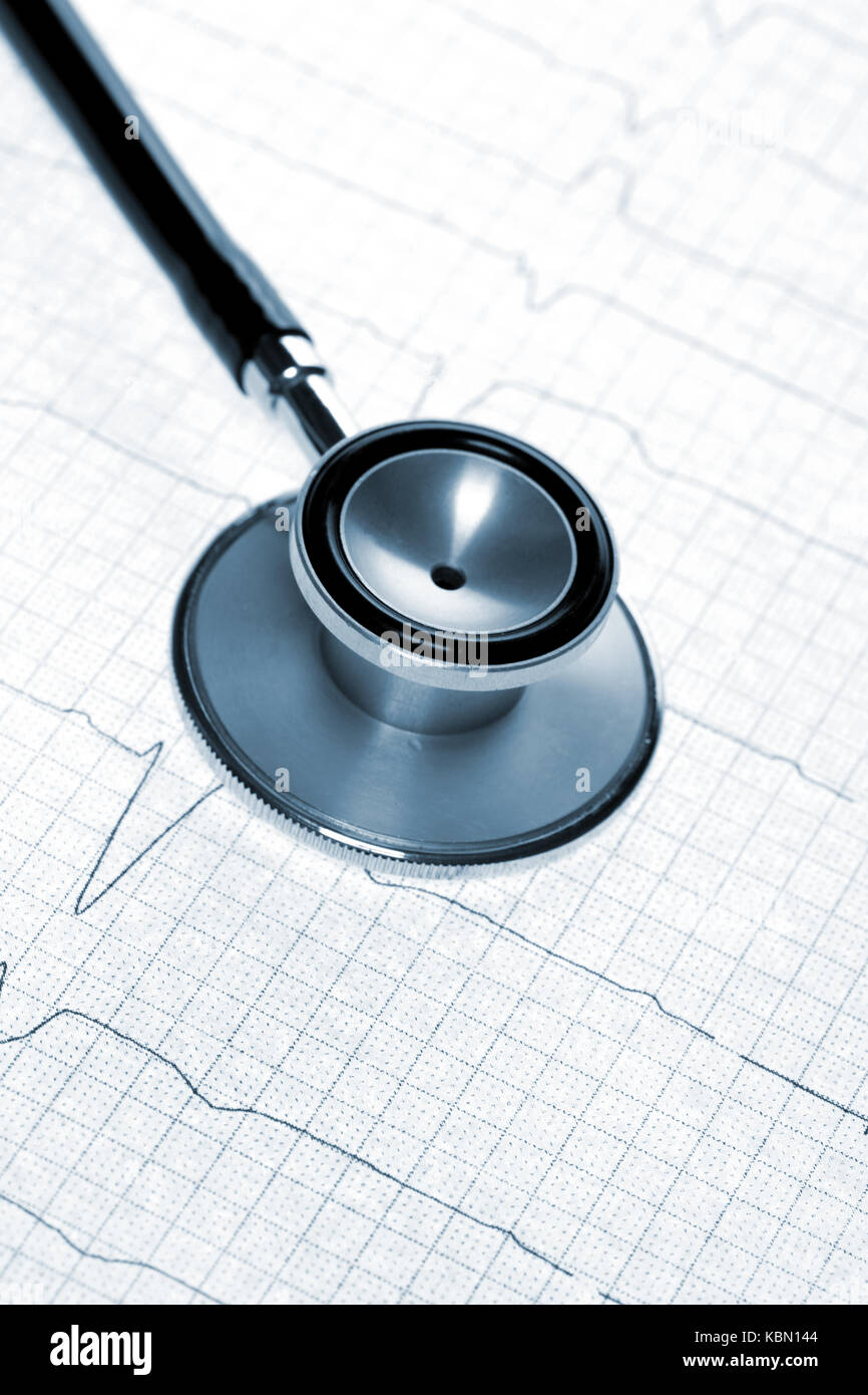 Close up view of a stethoscope on electrocardiogram background. Tinted ...