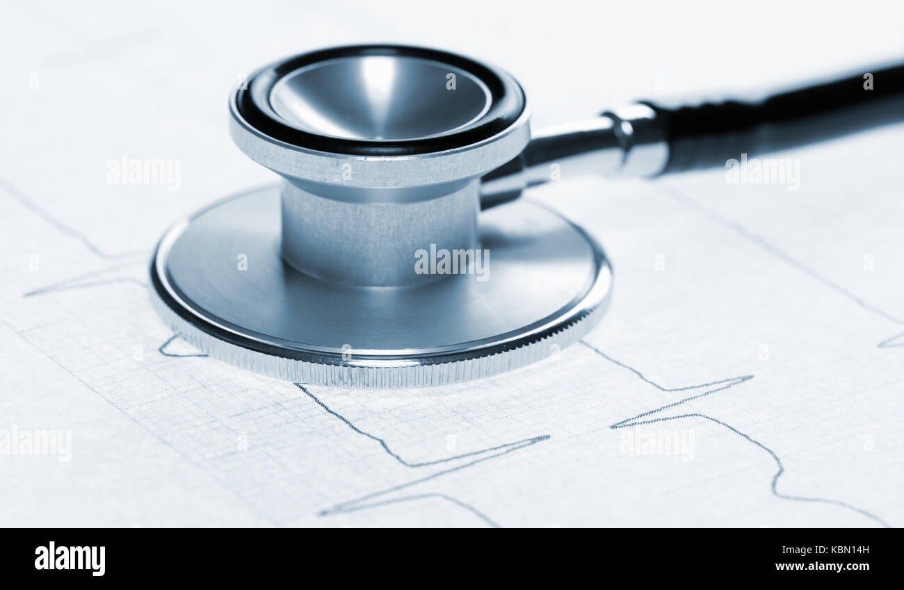 Close up view of a stethoscope on electrocardiogram background. Tinted ...