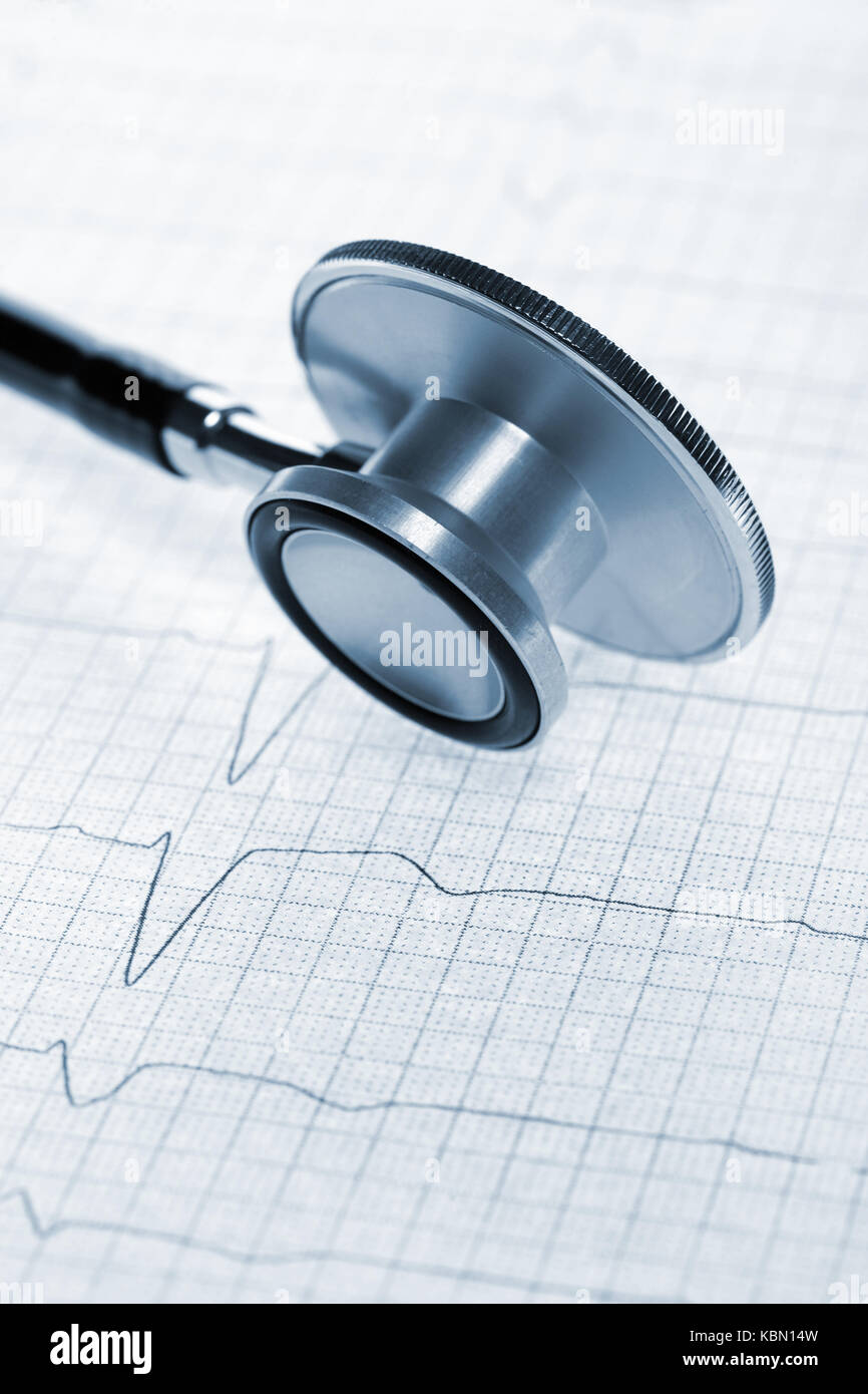 Close up view of a stethoscope on electrocardiogram background. Tinted ...