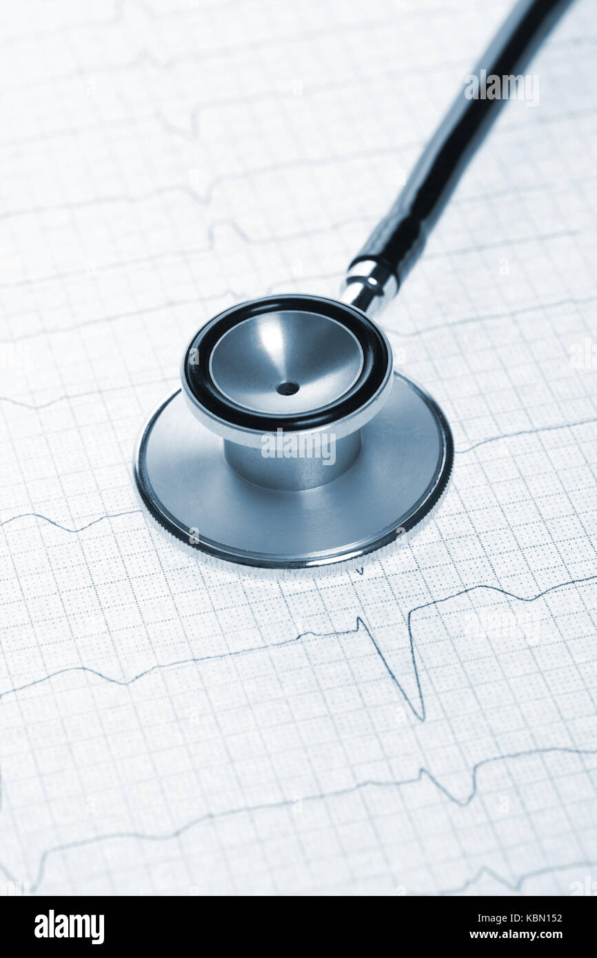 Close up view of a stethoscope on electrocardiogram background. Tinted ...