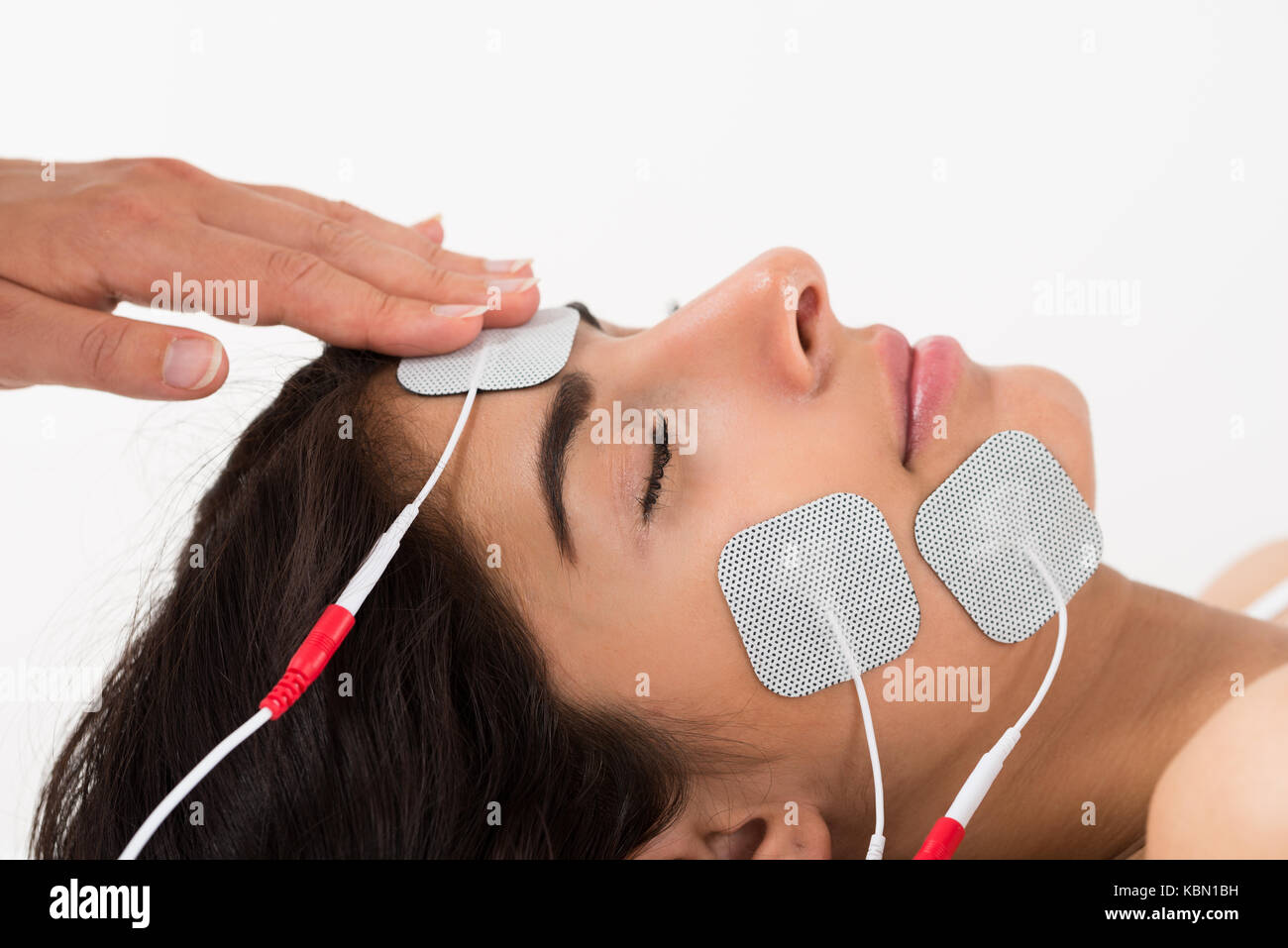 Close-up Of Hand Placing Electrodes On Young Woman's Face Stock Photo ...