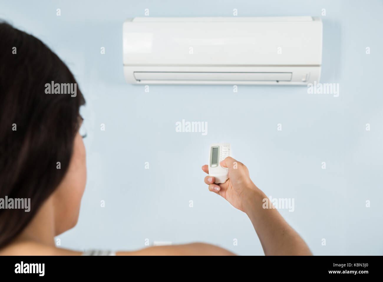 Close-up Of Young Woman Operating Air Conditioner With Remote Control ...