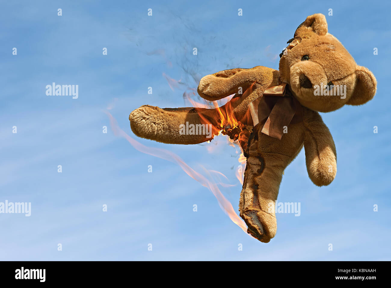 Burning teddy bear against a blue sky Stock Photo - Alamy