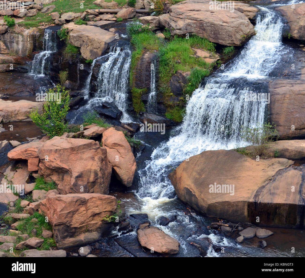 Three waterfalls cascade over large boulders Stock Photo - Alamy