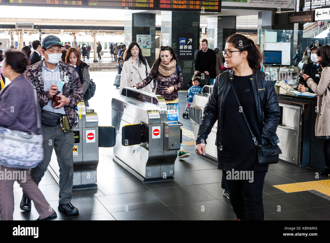Kyoto railway station. Commuters walking through ticket barriers into ...