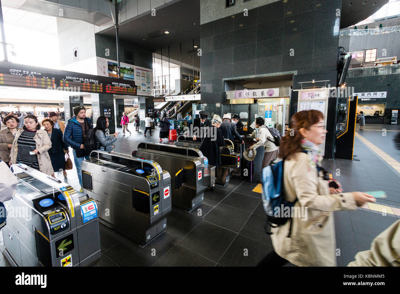 Kyoto railway station. Commuters walking through ticket barriers into ...
