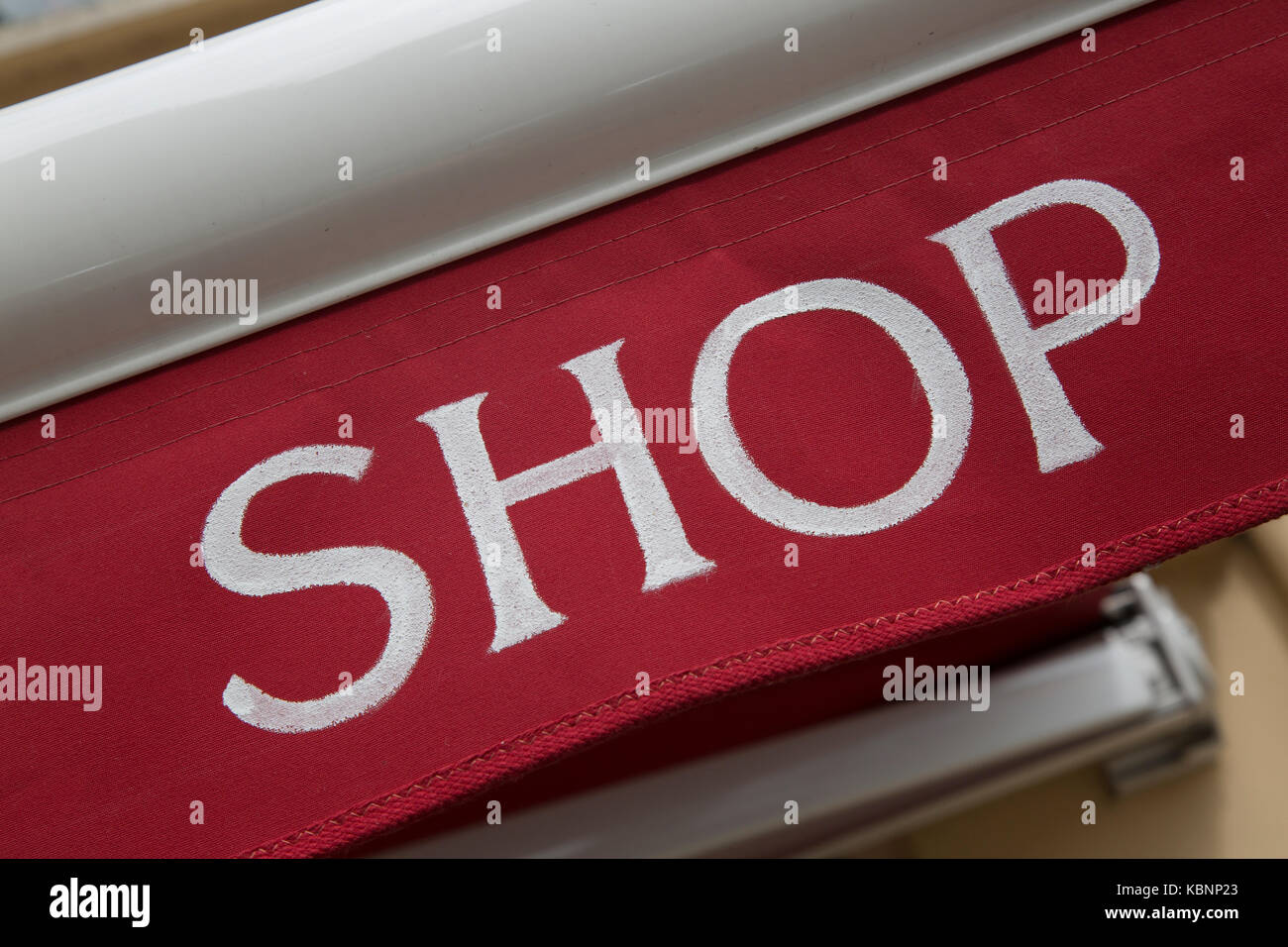 Red and White Shop Sign on Diagonal Slant Stock Photo - Alamy