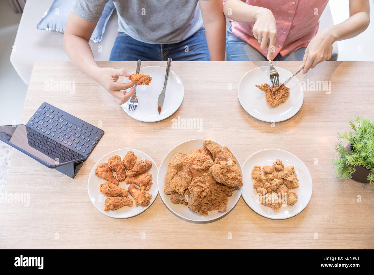 Young Asian Couples eating fried chicken together in living room of ...