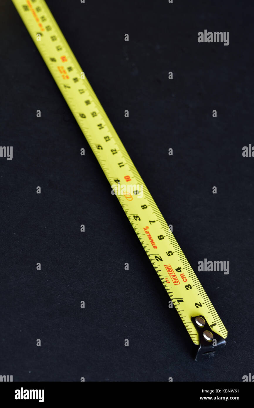 Yellow Stanley steel tape measure on black background Stock Photo - Alamy