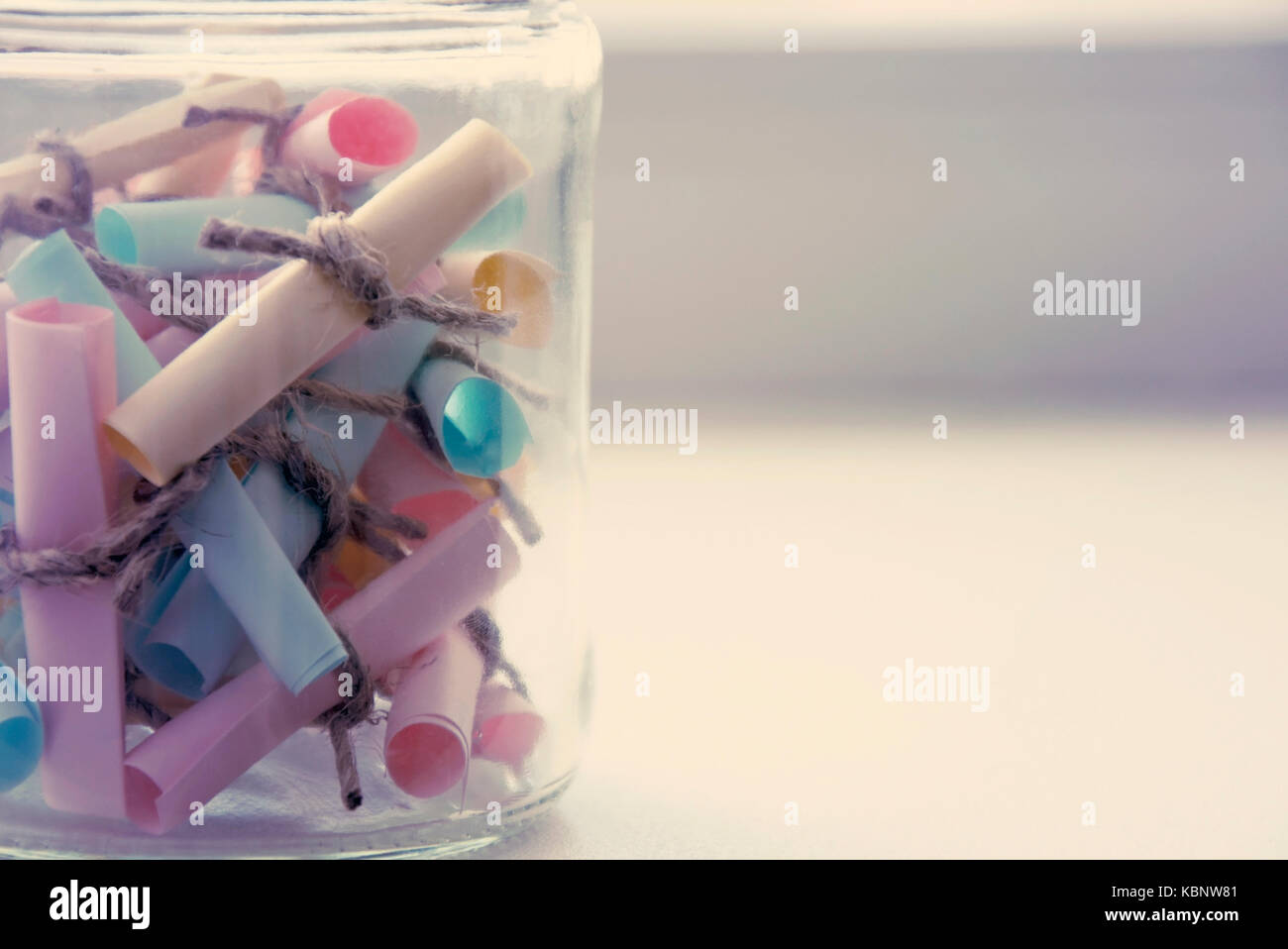 Glass jar with colored notes with blur and toning Stock Photo - Alamy