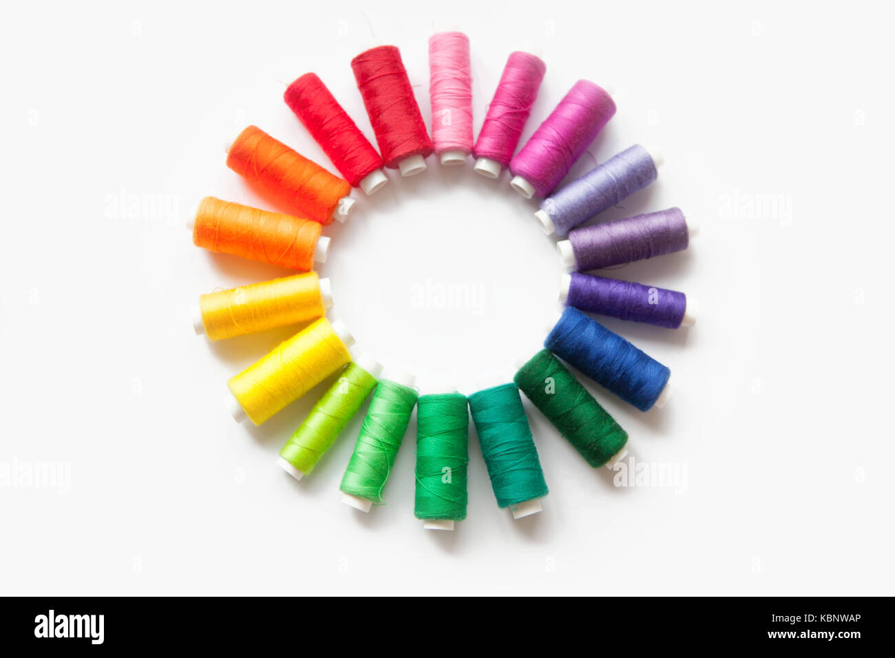 Color thread for sewing. White background. A circle of thread reels ...