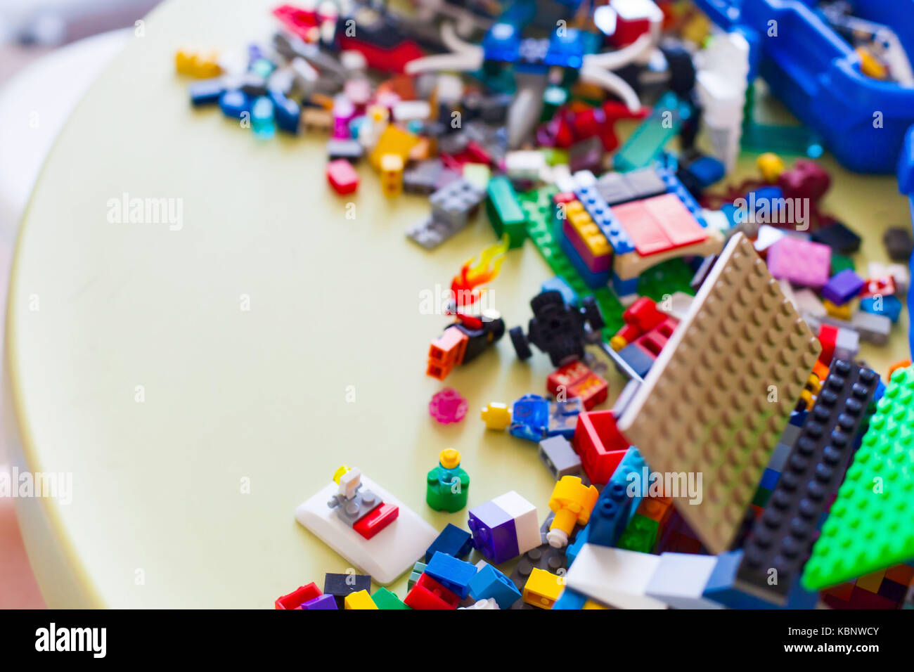 Little blond kid boy playing with lots of colorful plastic blocks ...