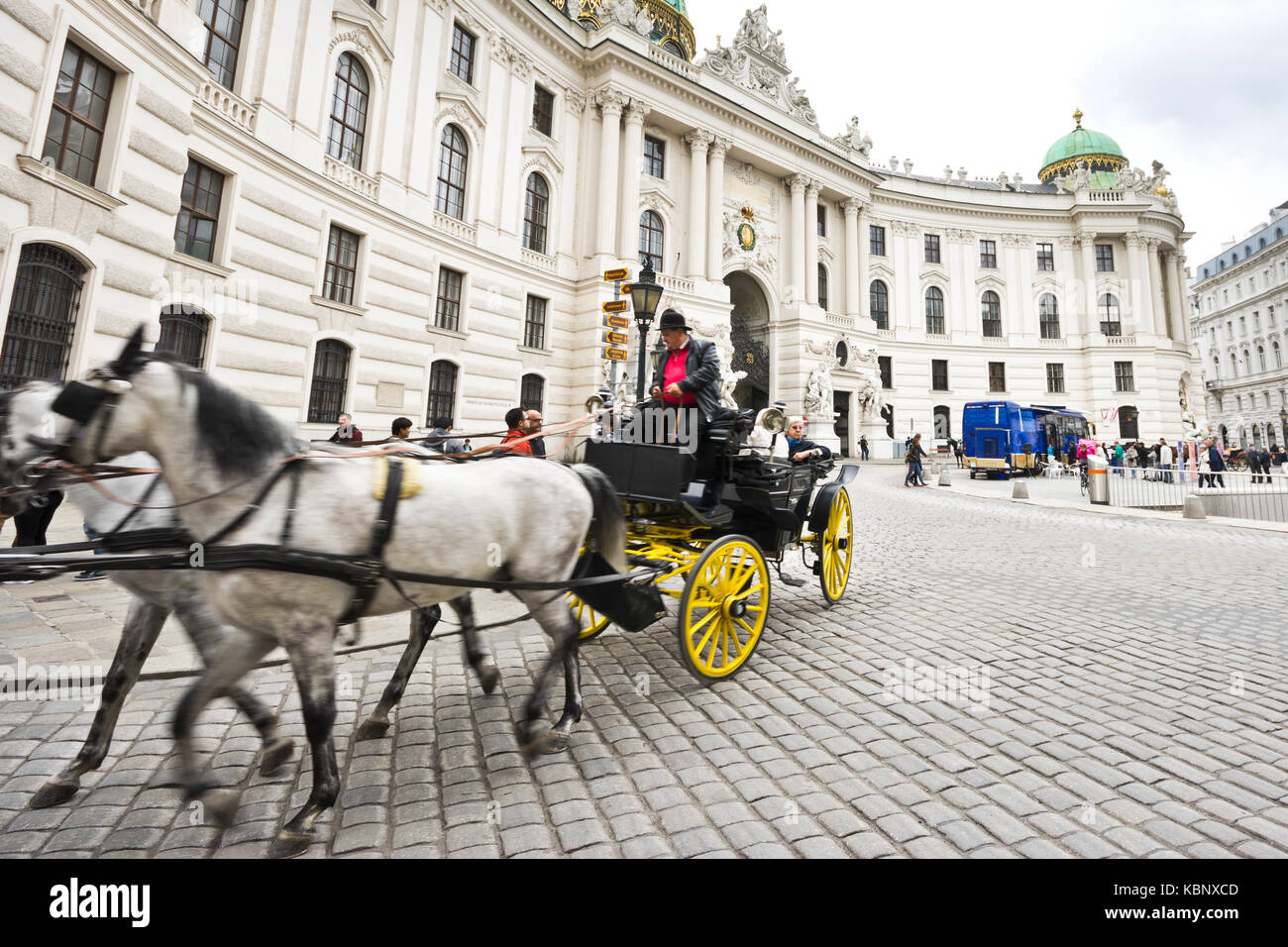 Famous horse-drawn carriage called fiaker passes by the Hofburg palace ...