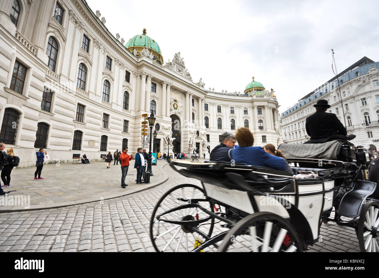 Famous horse-drawn carriage called fiaker passes by the Hofburg palace ...