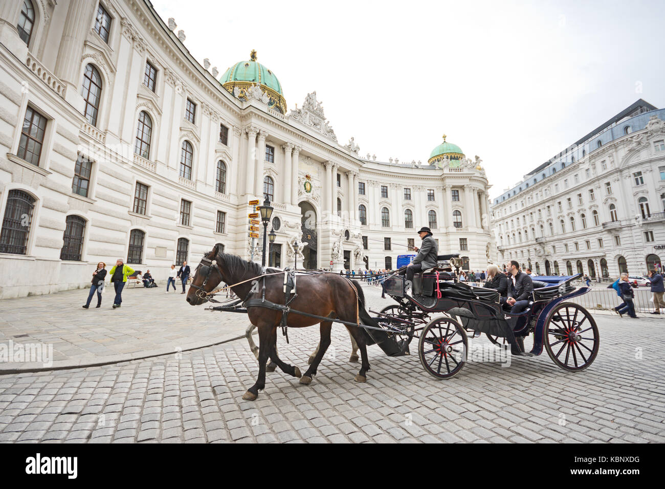 Famous horse-drawn carriage called fiaker passes by the Hofburg palace ...