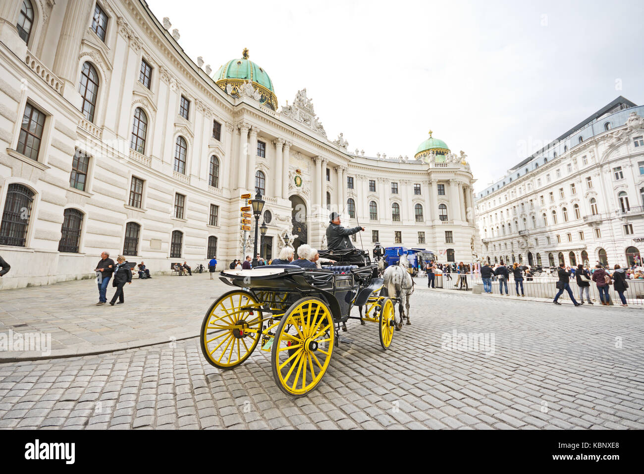 Famous horse-drawn carriage called fiaker passes by the Hofburg palace ...