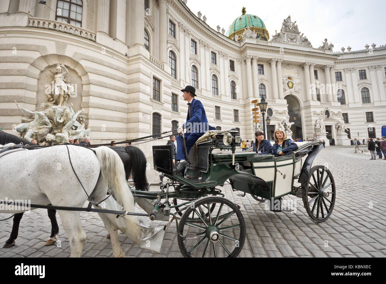 Famous horse-drawn carriage called fiaker passes by the Hofburg palace ...