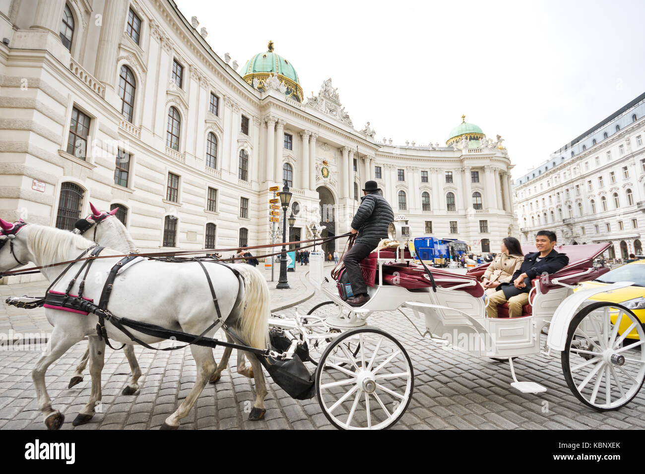 Famous horse-drawn carriage called fiaker with Asian tourists passes by ...