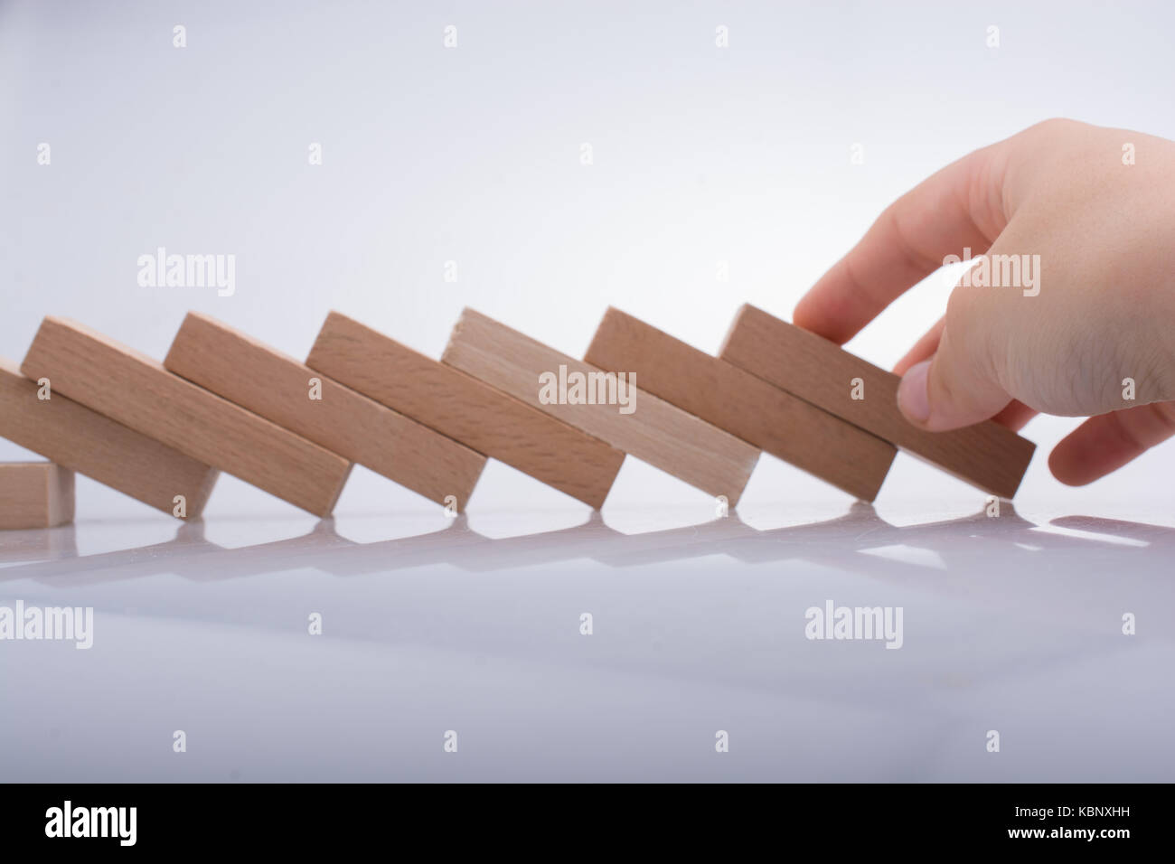 Hand holding wooden domino on a white background Stock Photo - Alamy