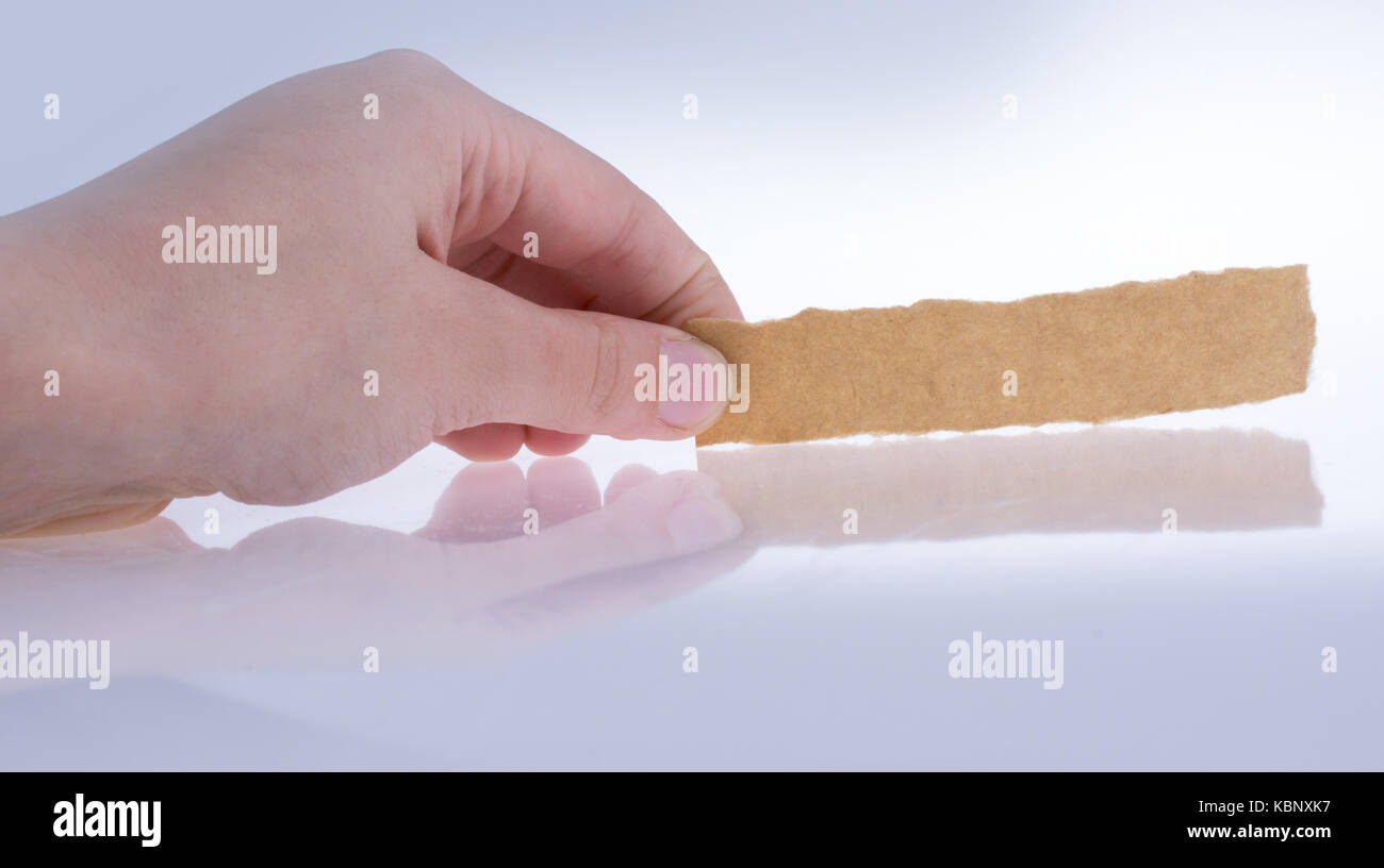 Hand holding a a piece of torn paper on a white background Stock Photo ...