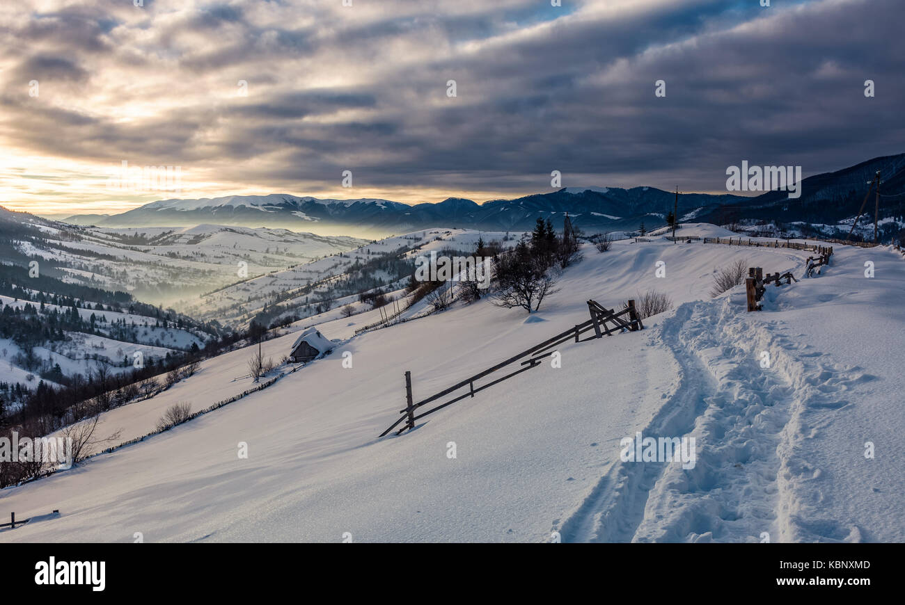 beautiful countryside in mountains. path in a snow near the wooden ...