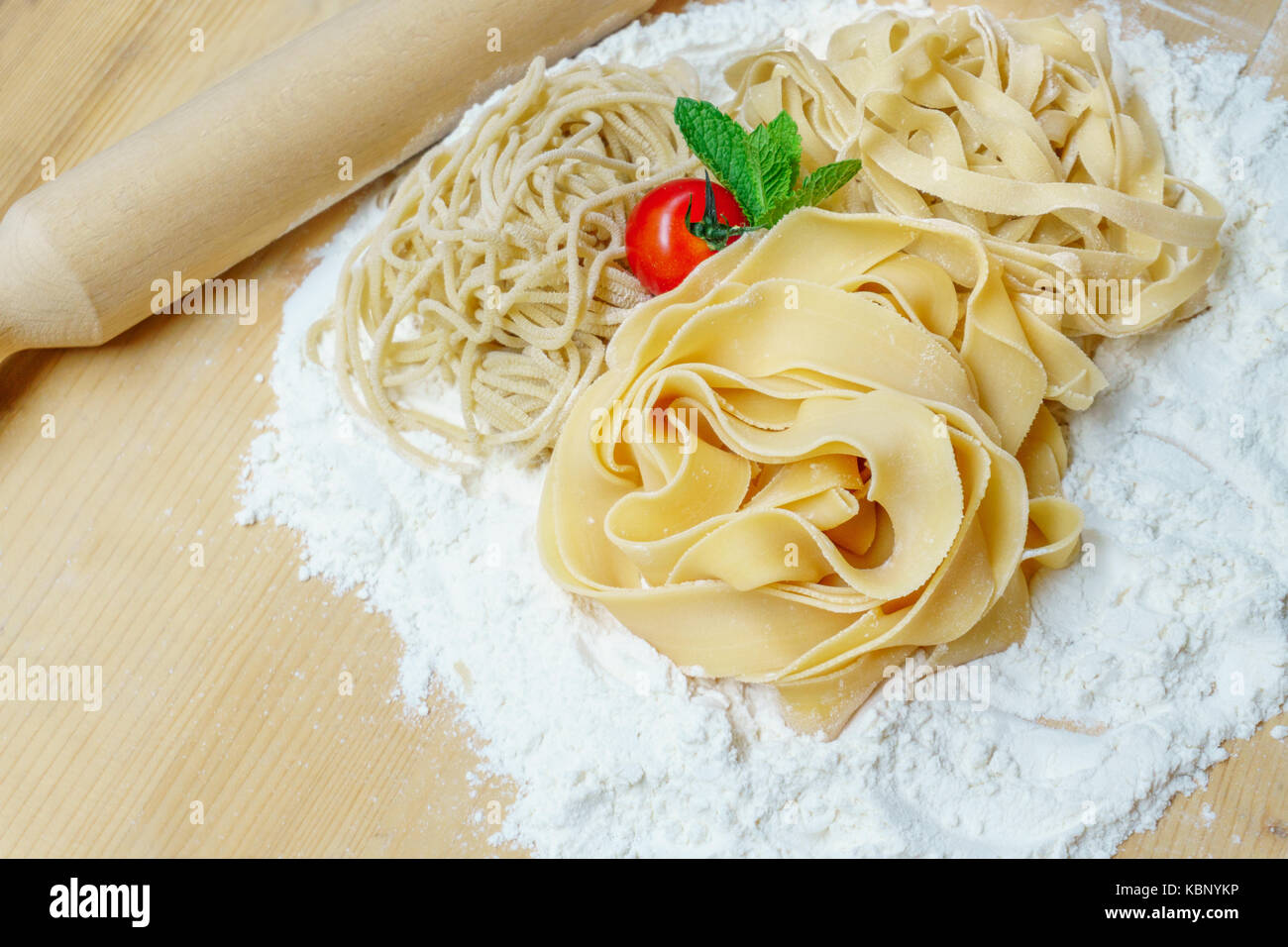 fresh pasta and rolling pin on kitchen table Stock Photo - Alamy