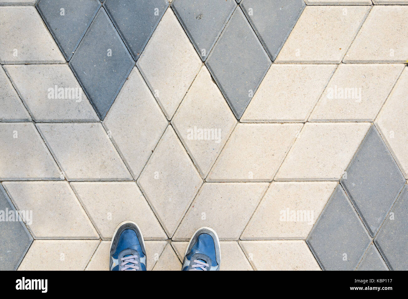 Blue Sneakers on Concrete Block Pavement. Top view Stock Photo - Alamy