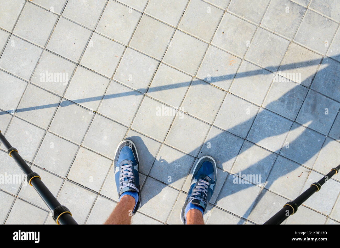 View from a tripod to the feet of a photographer taking pictures of the ...