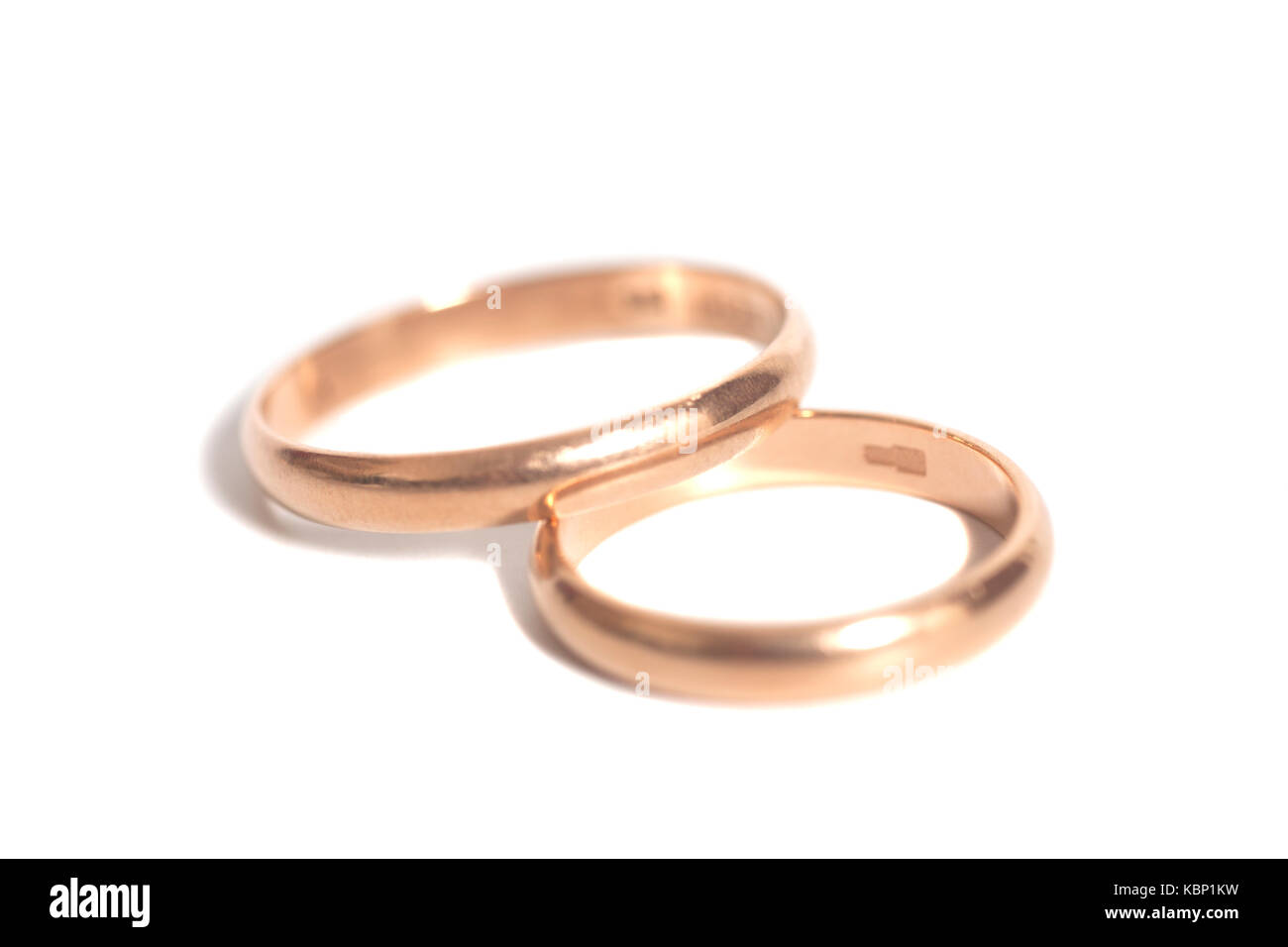 Two golden wedding rings isolated on white background Stock Photo - Alamy