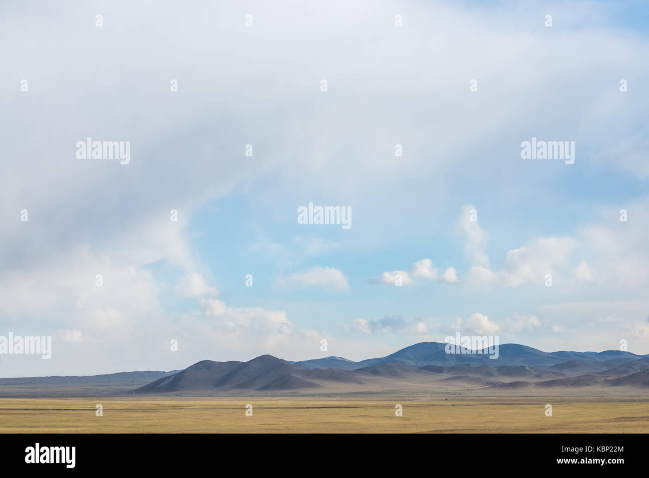 panoramic view of plain with road at root of mountains Stock Photo - Alamy