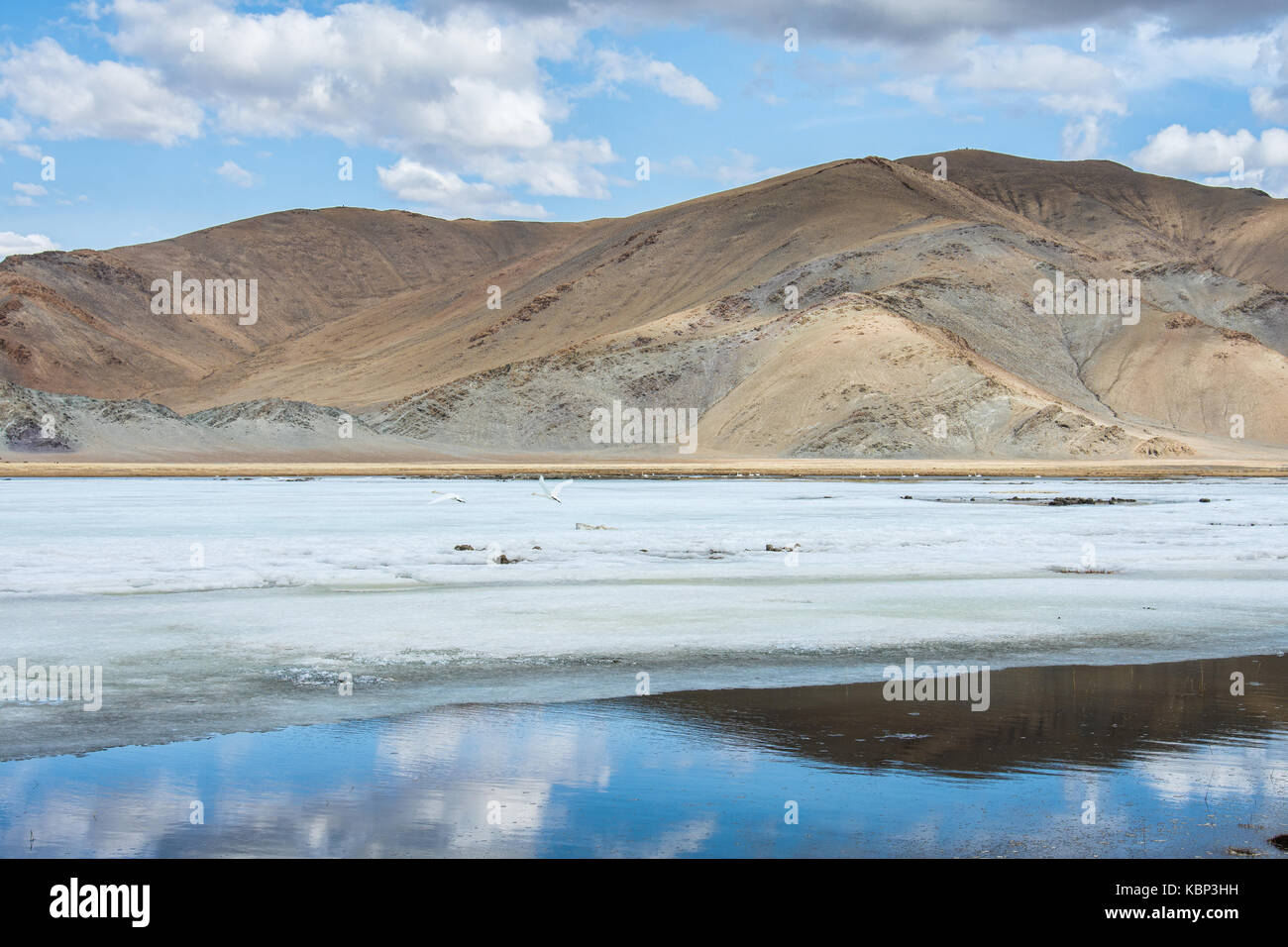 cold iced lake at cloudy day with great mountains on background Stock ...