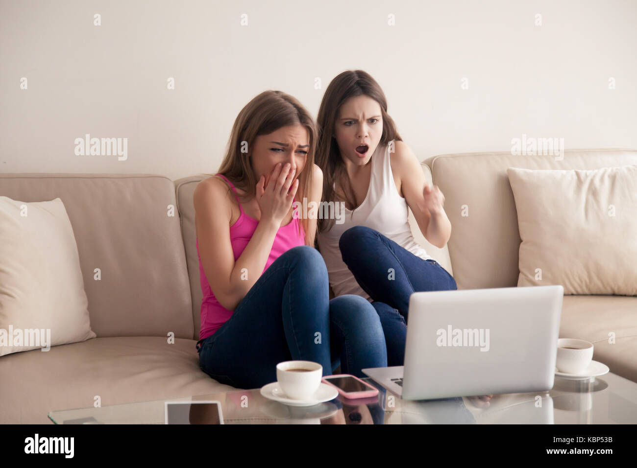 Two scared girlfriends screaming while watching horror movie Stock ...