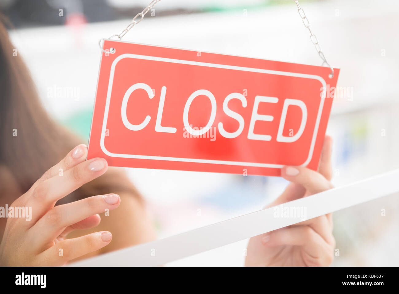 Closeup of female owner holding closed sign in clothing store Stock ...