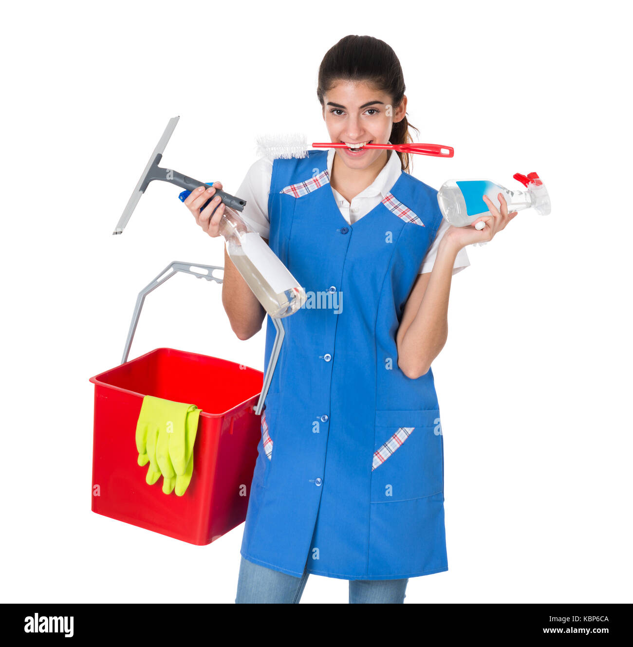 Portrait of confident female worker carrying bucket with cleaning ...