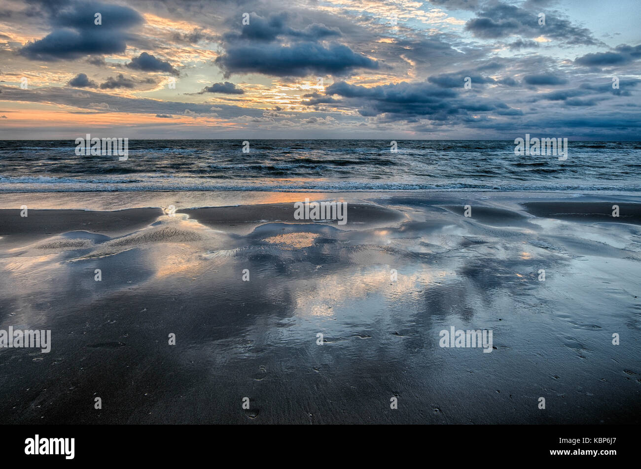 Reflections of clouds on sandy beach Stock Photo - Alamy
